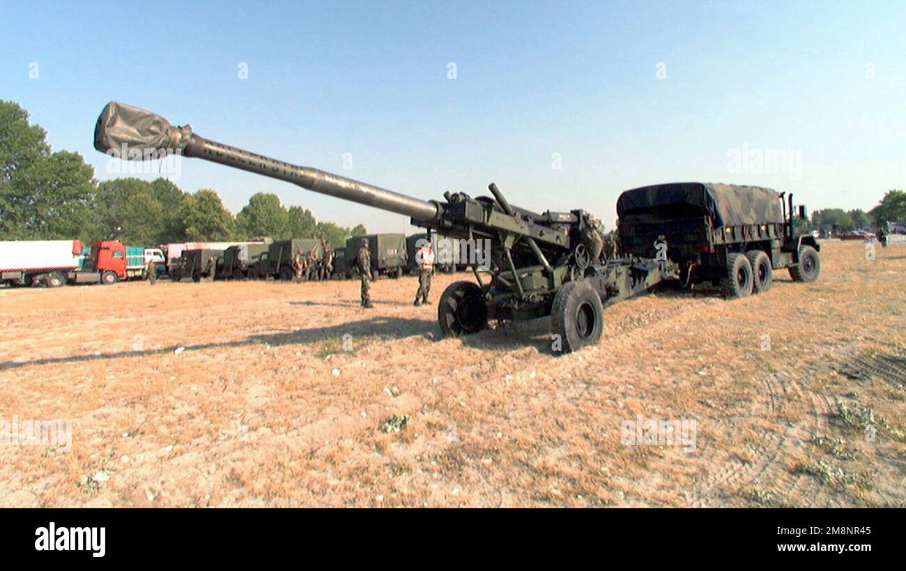 A 155mm howitzer M198, towed by an M939 series (6x6) 5 ton cargo truck ...