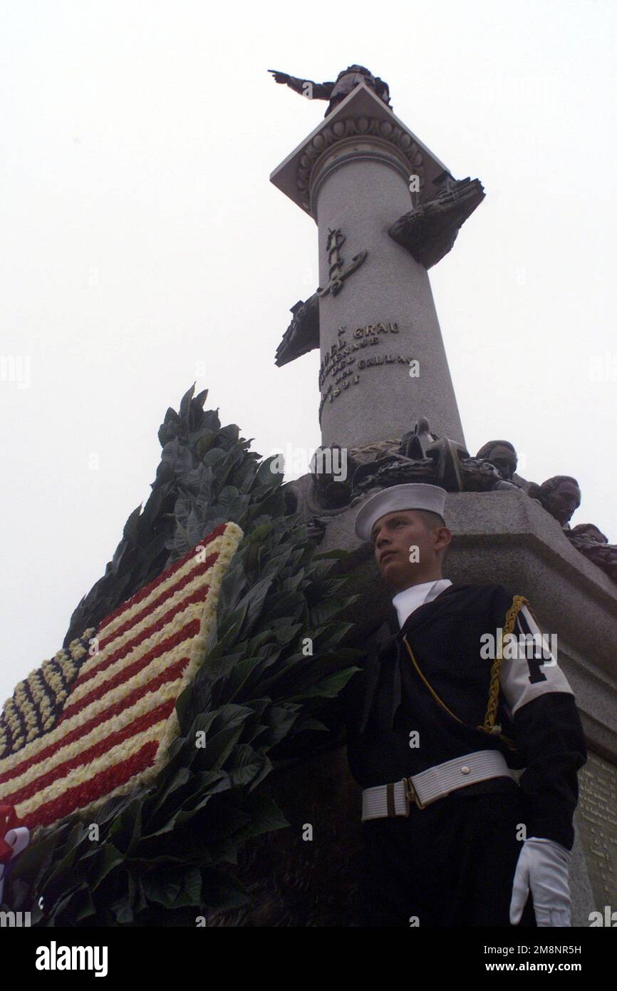 A Peruvian sailor stands next to a wreath laid by American military ...
