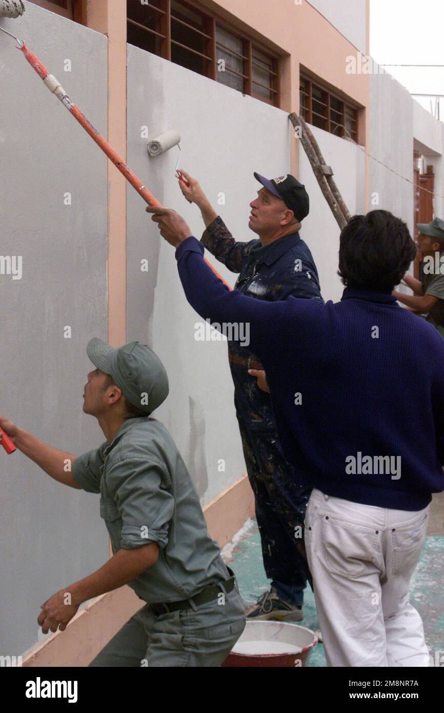 US Navy PETTY Officer Second Class James Heideman (center) lends a ...