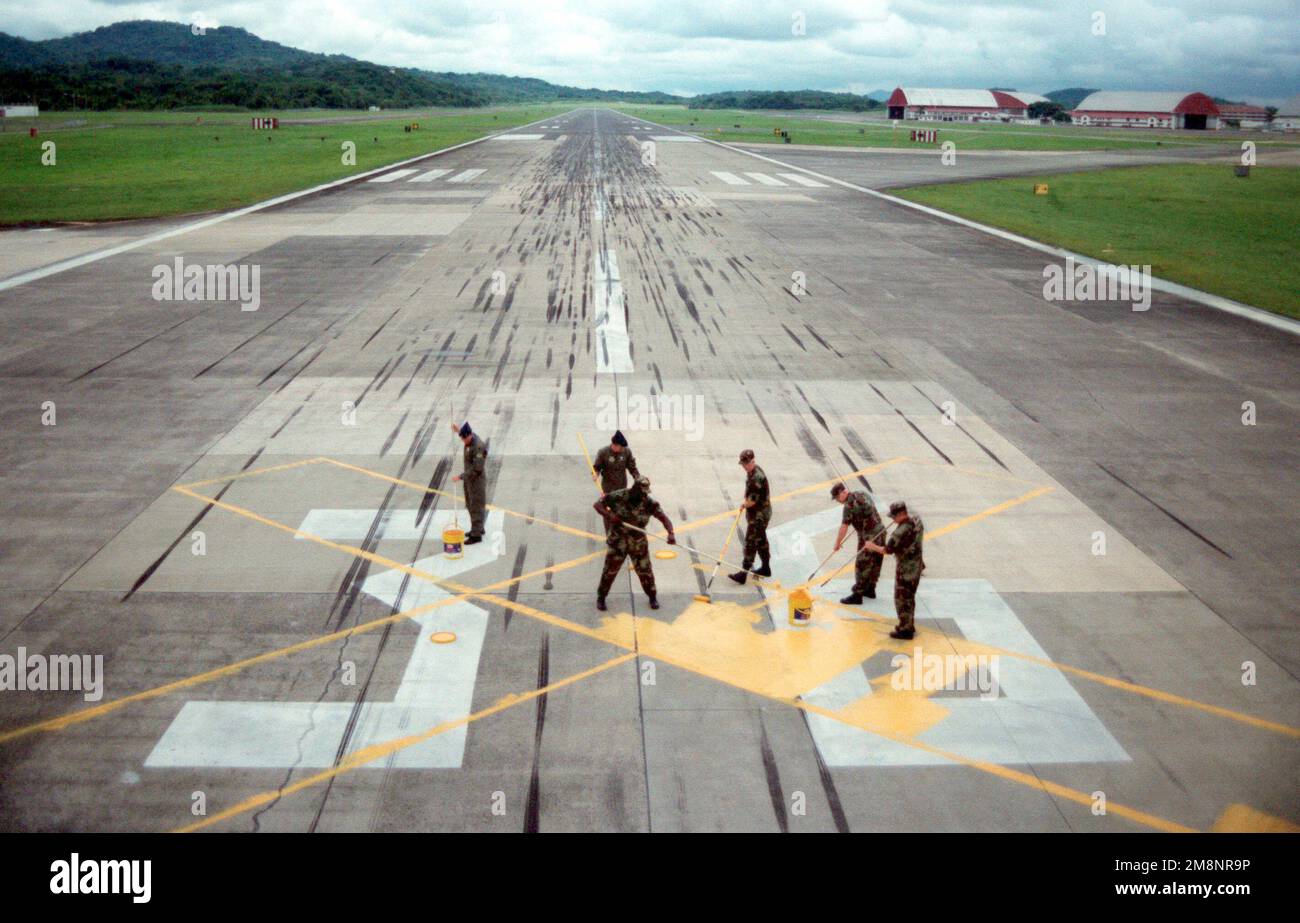 U.S. Army and Air Force personnel paint a giant yellow cross over the ...