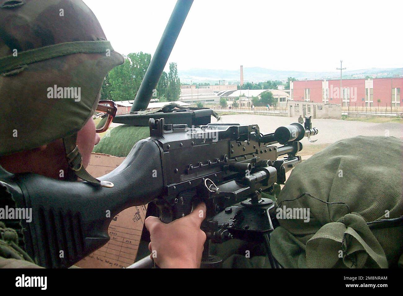 Lance Corporal Brian A. Justice, looking through the site of an M240G ...
