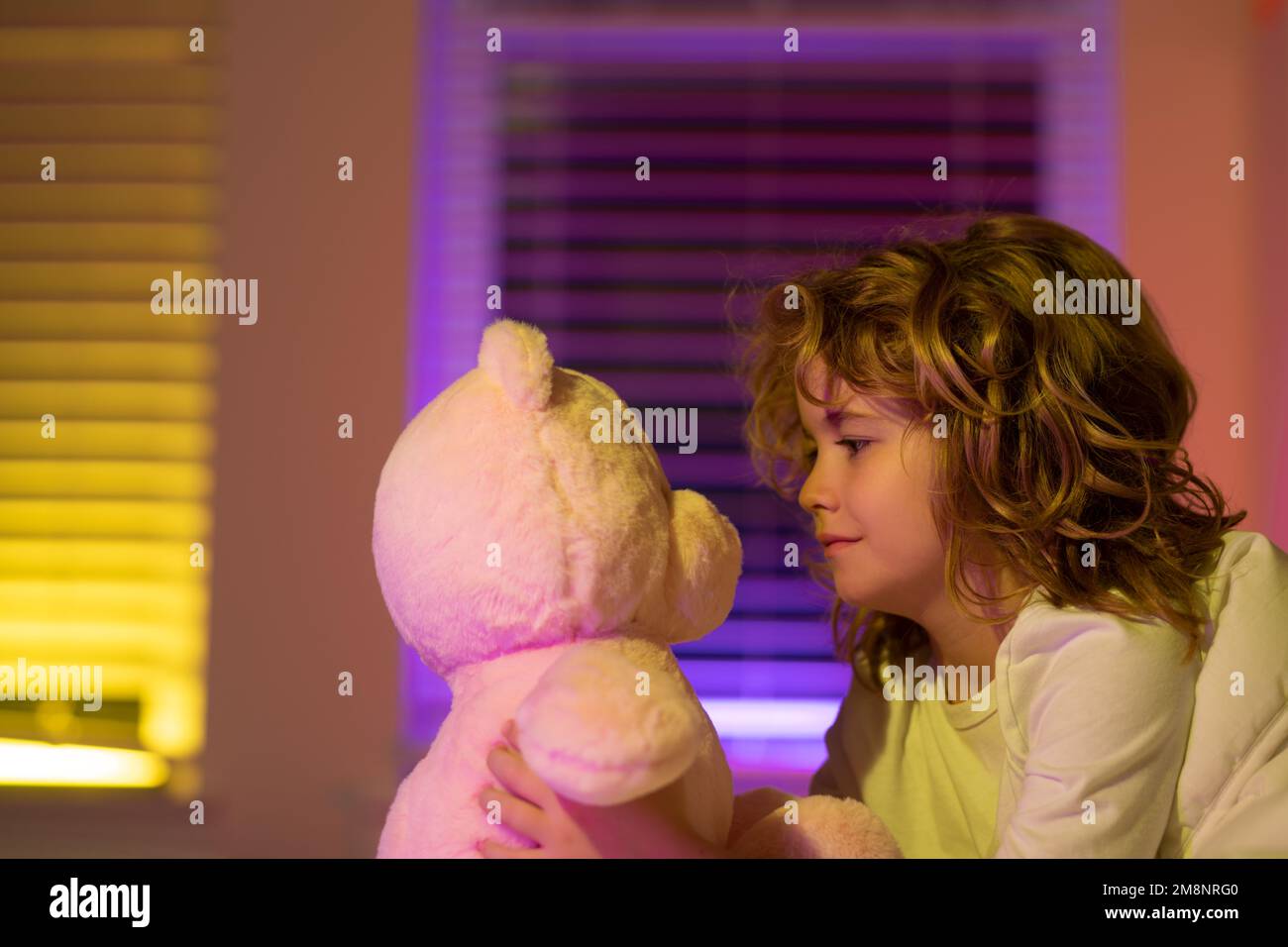 Child play with toy teddy bear. Kid in bed with toy teddy bear. Nap and ...