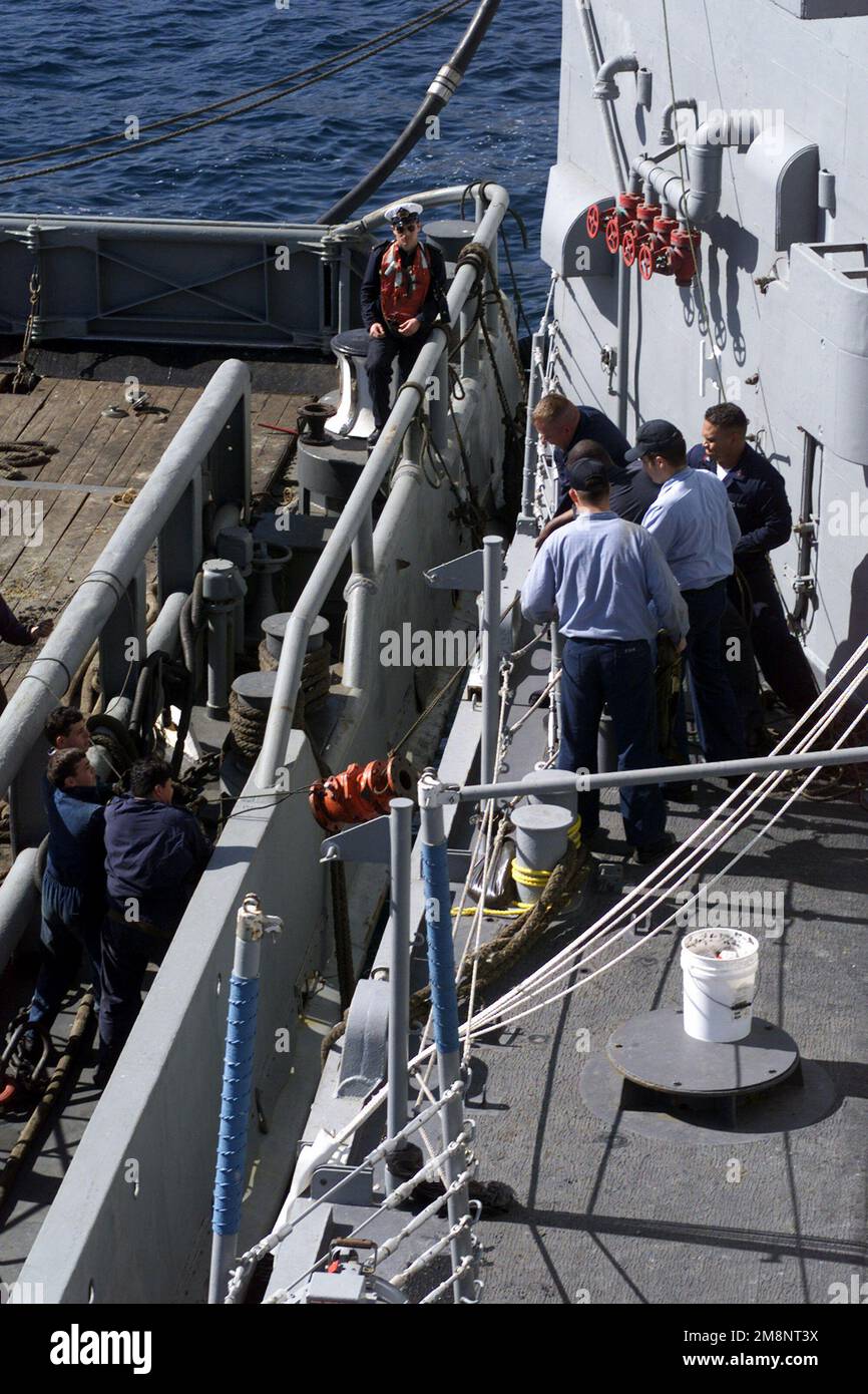 Crew members from USS REUBEN JAMES (FFG 57) receive an adapter fitting ...