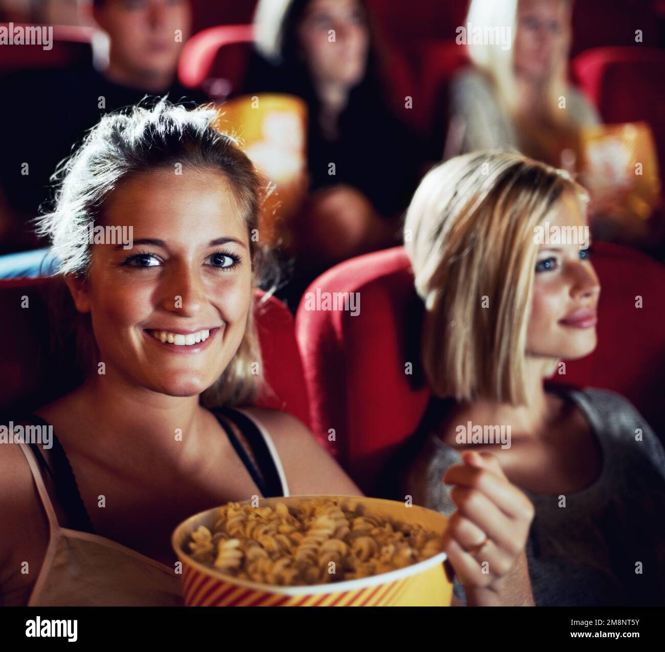 I took the combo deal. A pretty young girl eating popcorn and watching ...