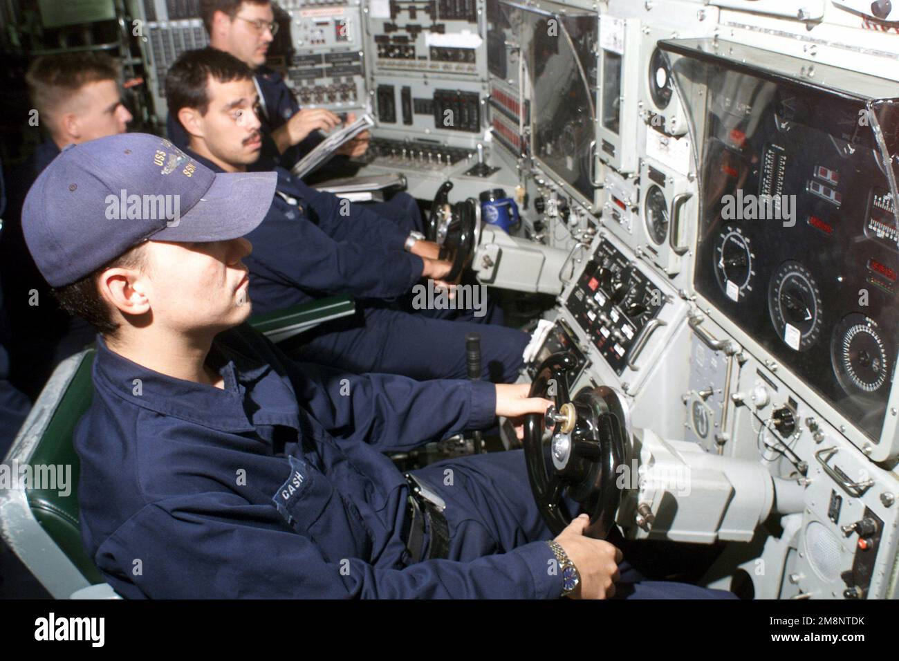 US Navy Storekeeper SEAMAN Jeremy Cash sits at the helm of USS TUCSON ...