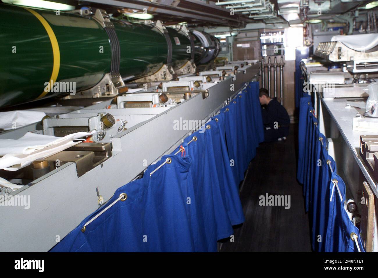 An MK48 torpedo sits above crewmen's bunks aboard the USS TUCSON (SSN ...