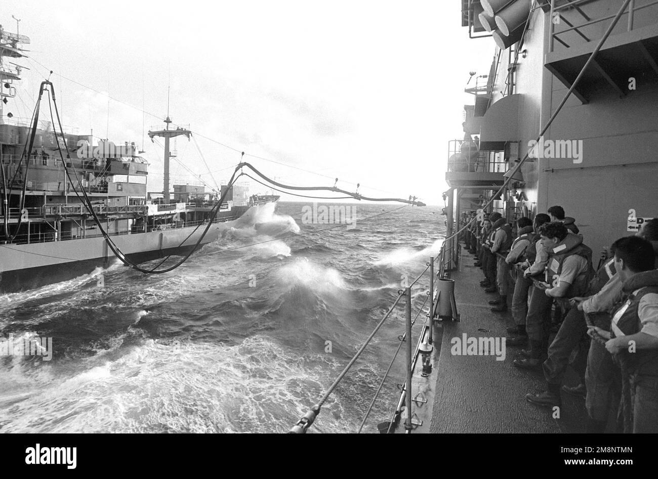 Crew members aboard the destroyer USS PETERSON (DD-969) handle a line ...