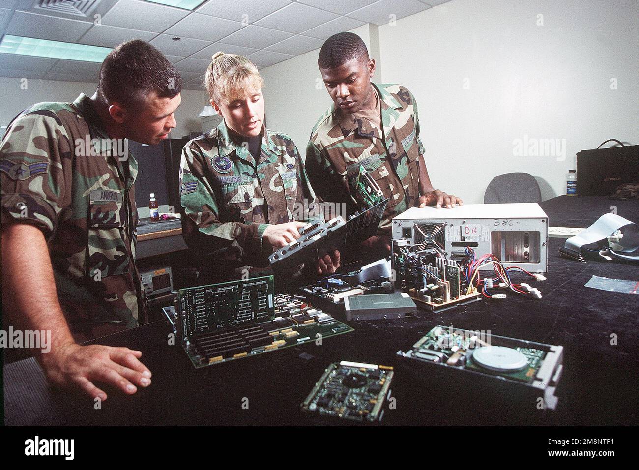 Instructor SENIOR AIRMAN Sharee Kambouris (center) disassembles a ...