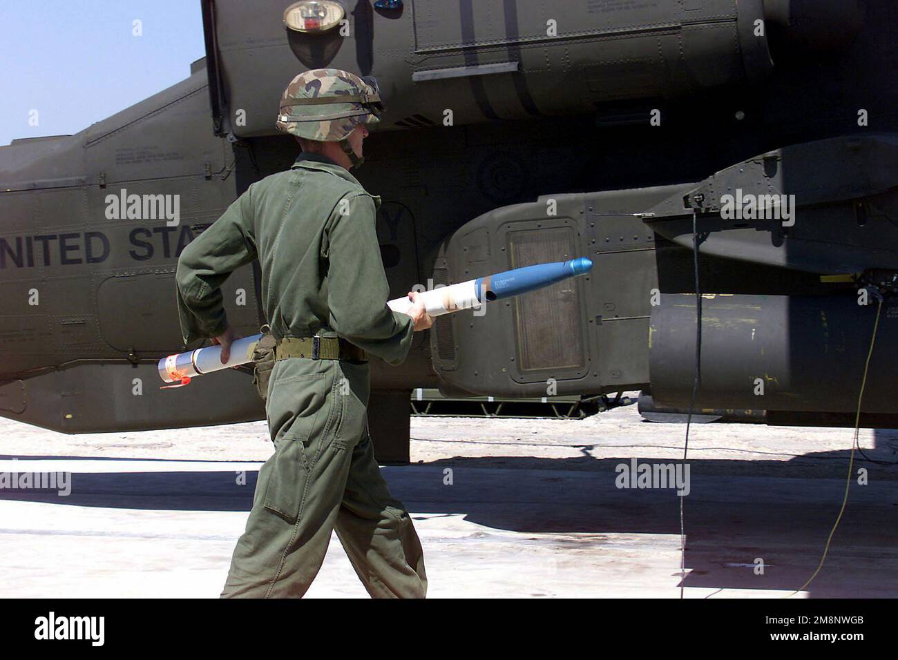 US Army Sergeant John P. Green loads a missile onto an AH-64D Apache ...
