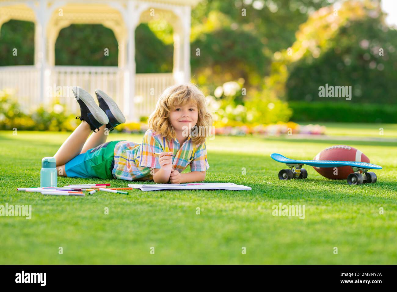 Little painter draw pictures outdoor. School kid drawing in summer park ...