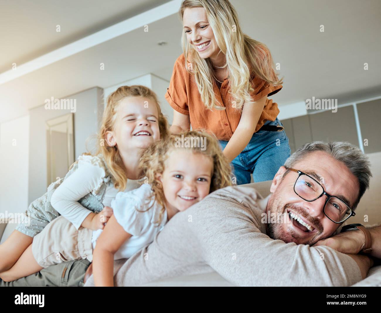 A happy Caucasian family of four relaxing on the sofa at home. Loving ...