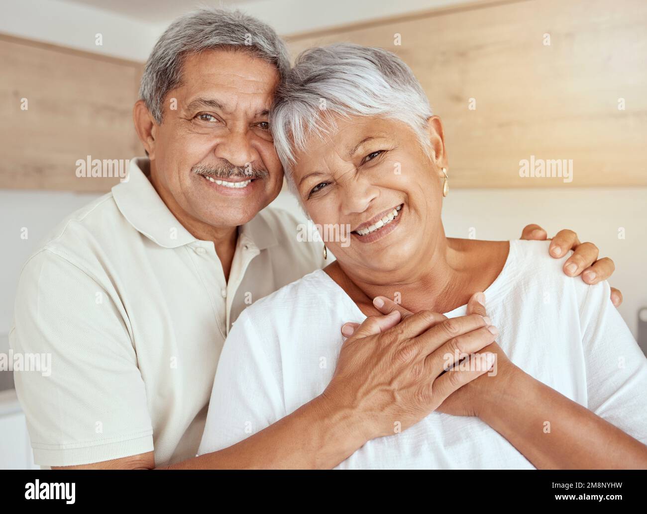 Portrait of mixed race senior couple hugging in the morning at home ...