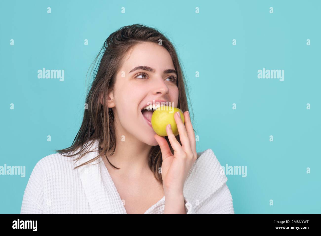 Woman with apples. Young woman eating apple over blue isolated ...