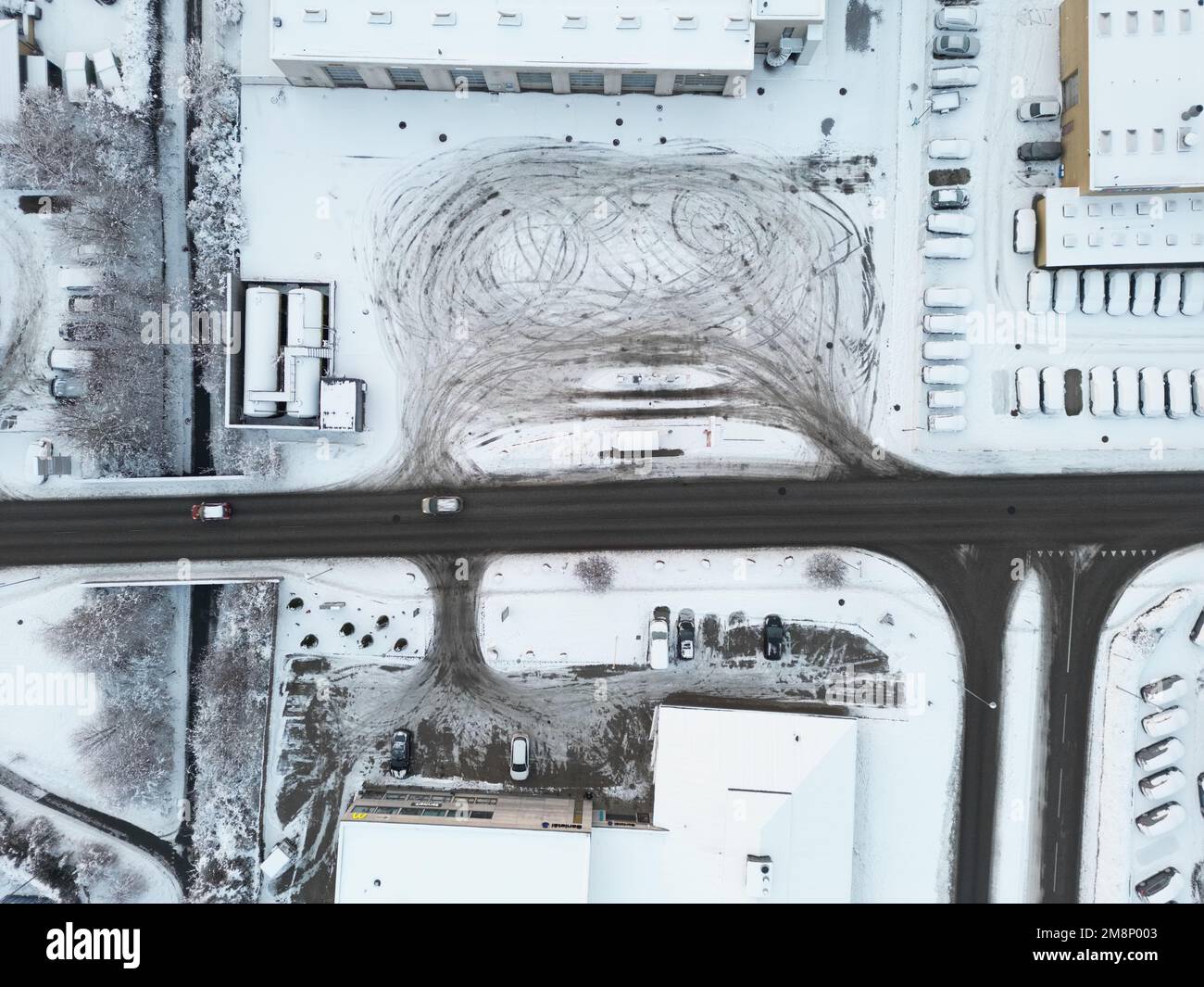 An aerial top view of a road crossing through a snow-covered area with ...