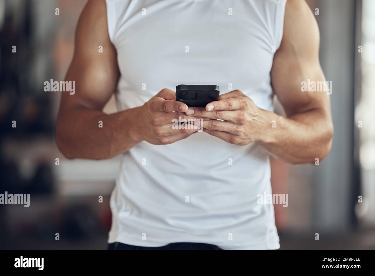 Man using his cellphone in the gym. Man browsing an app online on his ...