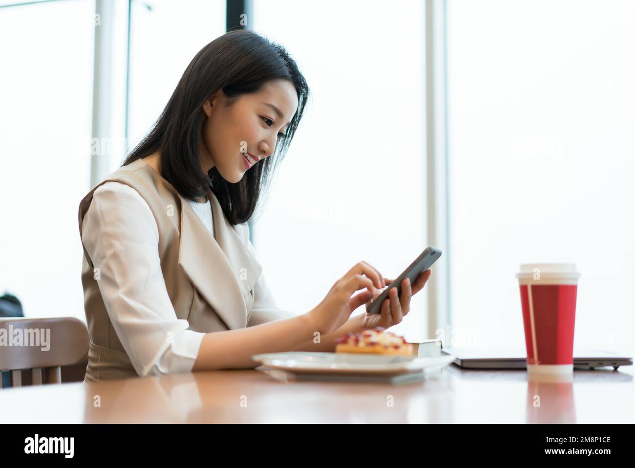 A young woman using a cell phone in a restaurant Stock Photo - Alamy