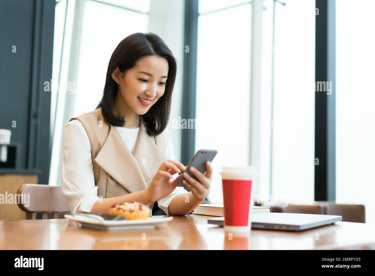 A young woman using a cell phone in a restaurant Stock Photo - Alamy