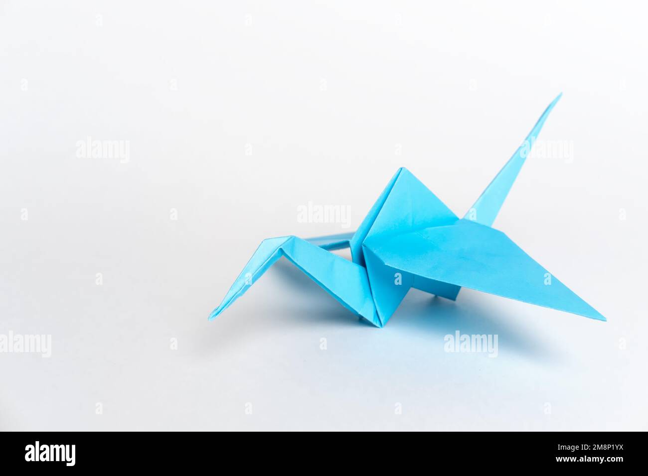 Traditional Japanese origami cranes made of blue paper on a white ...