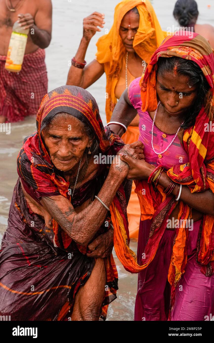 Rathi Devi, 82, being helped by a kin after taking a ritualistic bath in Hooghly River on the ...