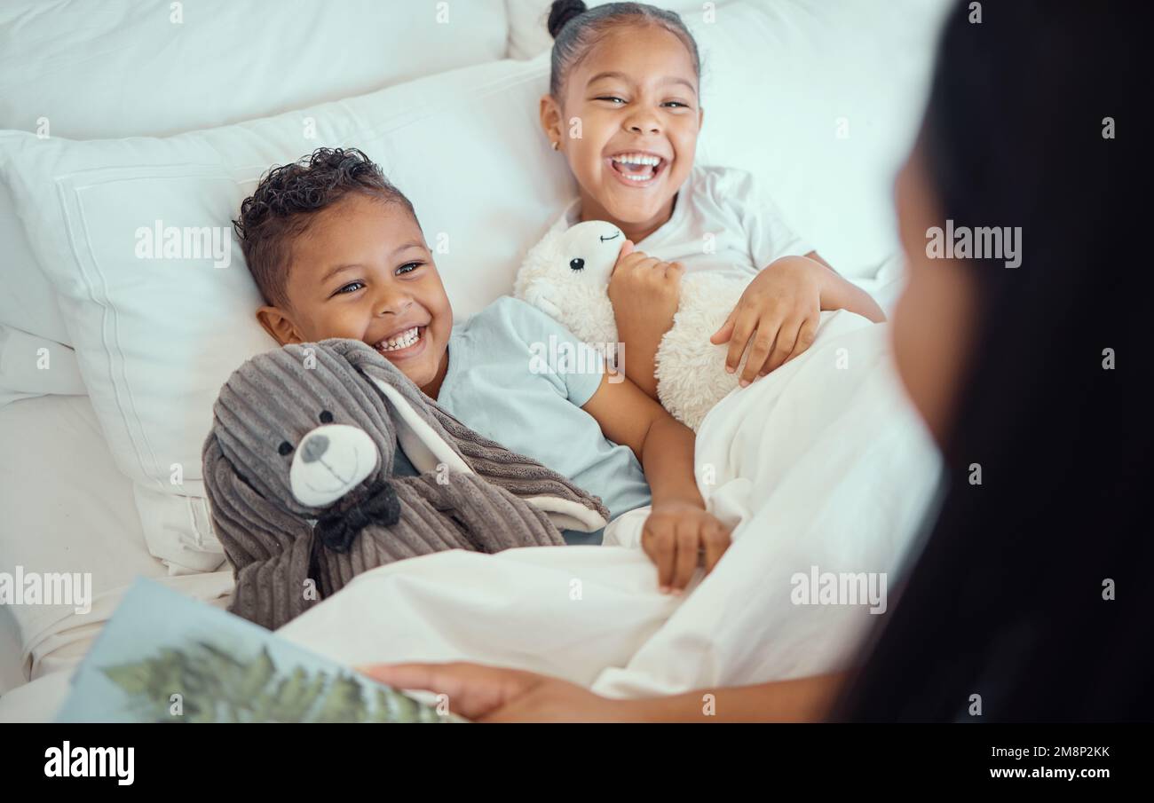 Happy little sibling brother and sister lying comfortable in bed while ...