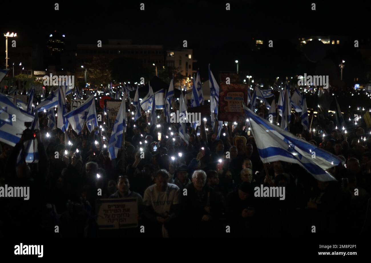 Protesters with lights on their phones wave flags during the ...