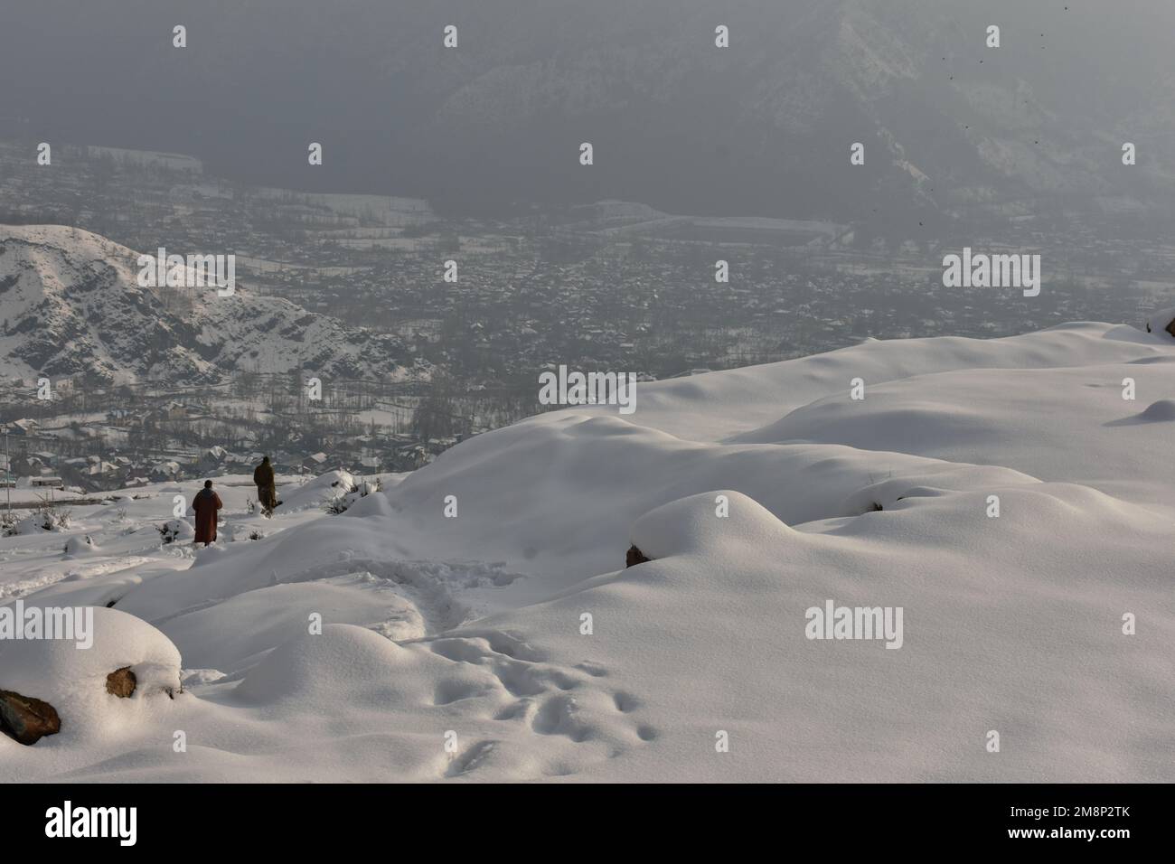 Srinagar, India. 14th Jan, 2023. Visitors walk through a snow covered ...