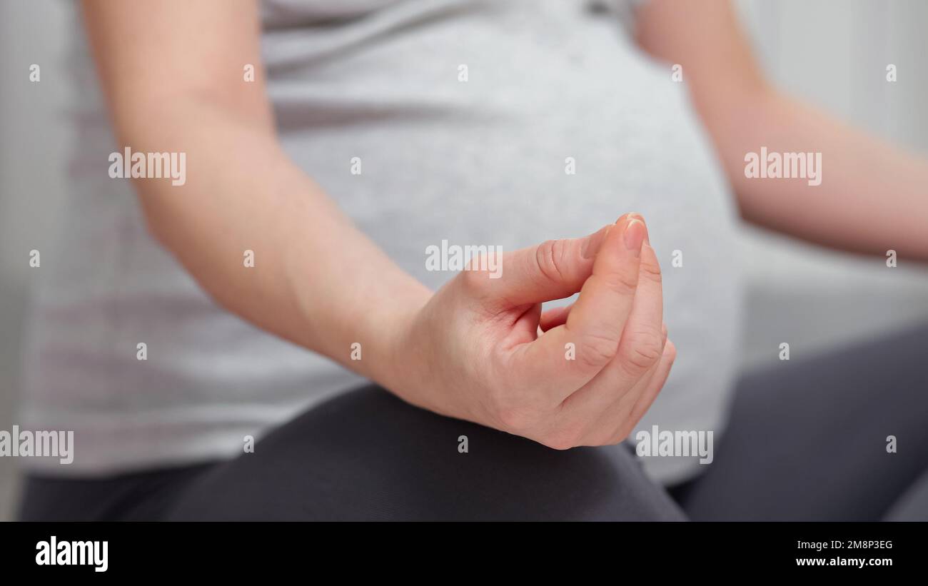 Pregnant woman meditates in lotus position at home Stock Photo - Alamy