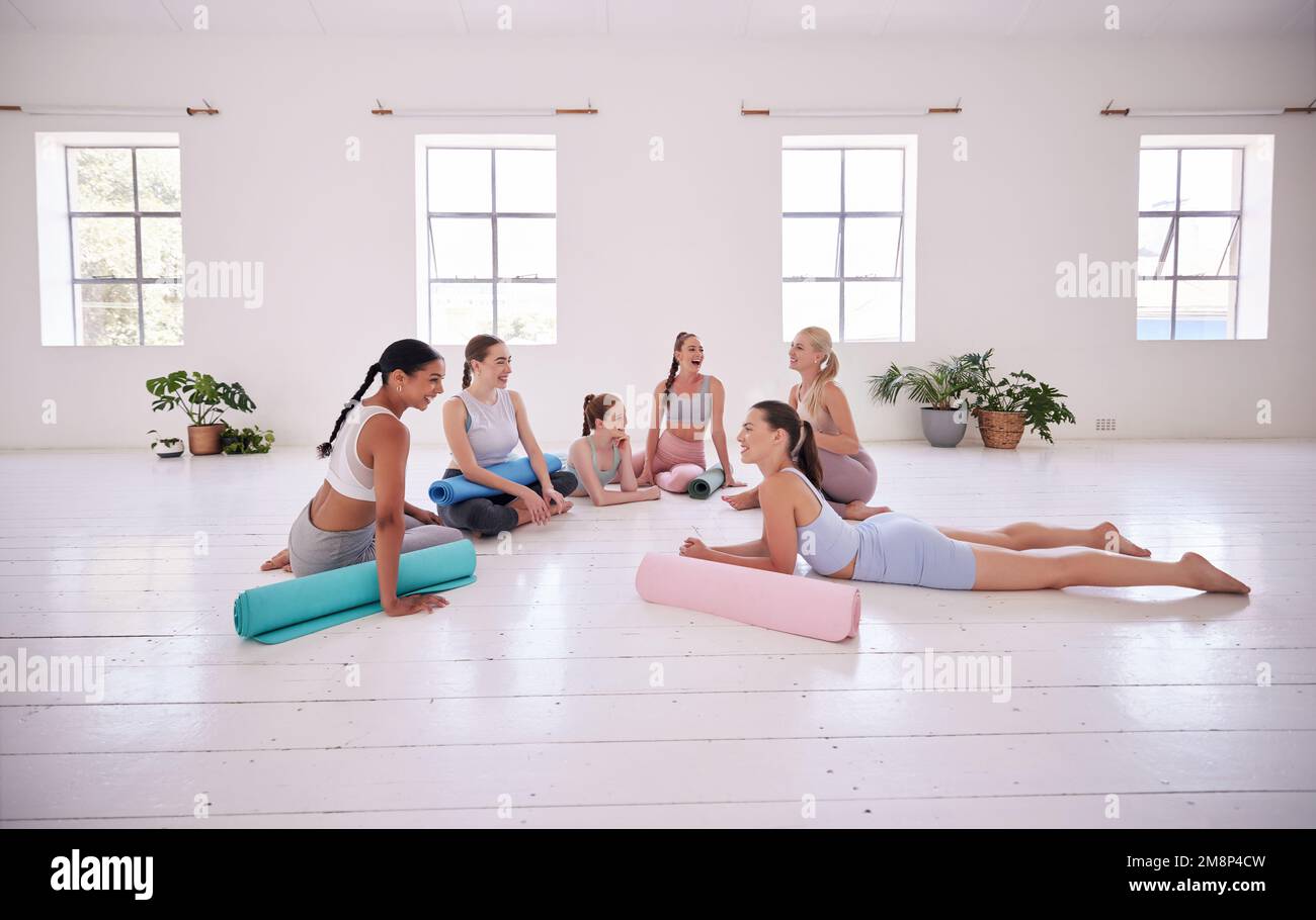 Happy friends relaxing before yoga class together. Young women bonding ...