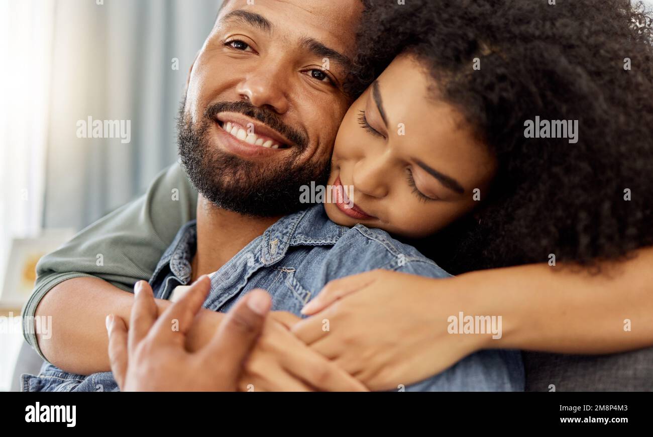 Happy mixed race couple embracing while relaxing at home. Hispanic ...