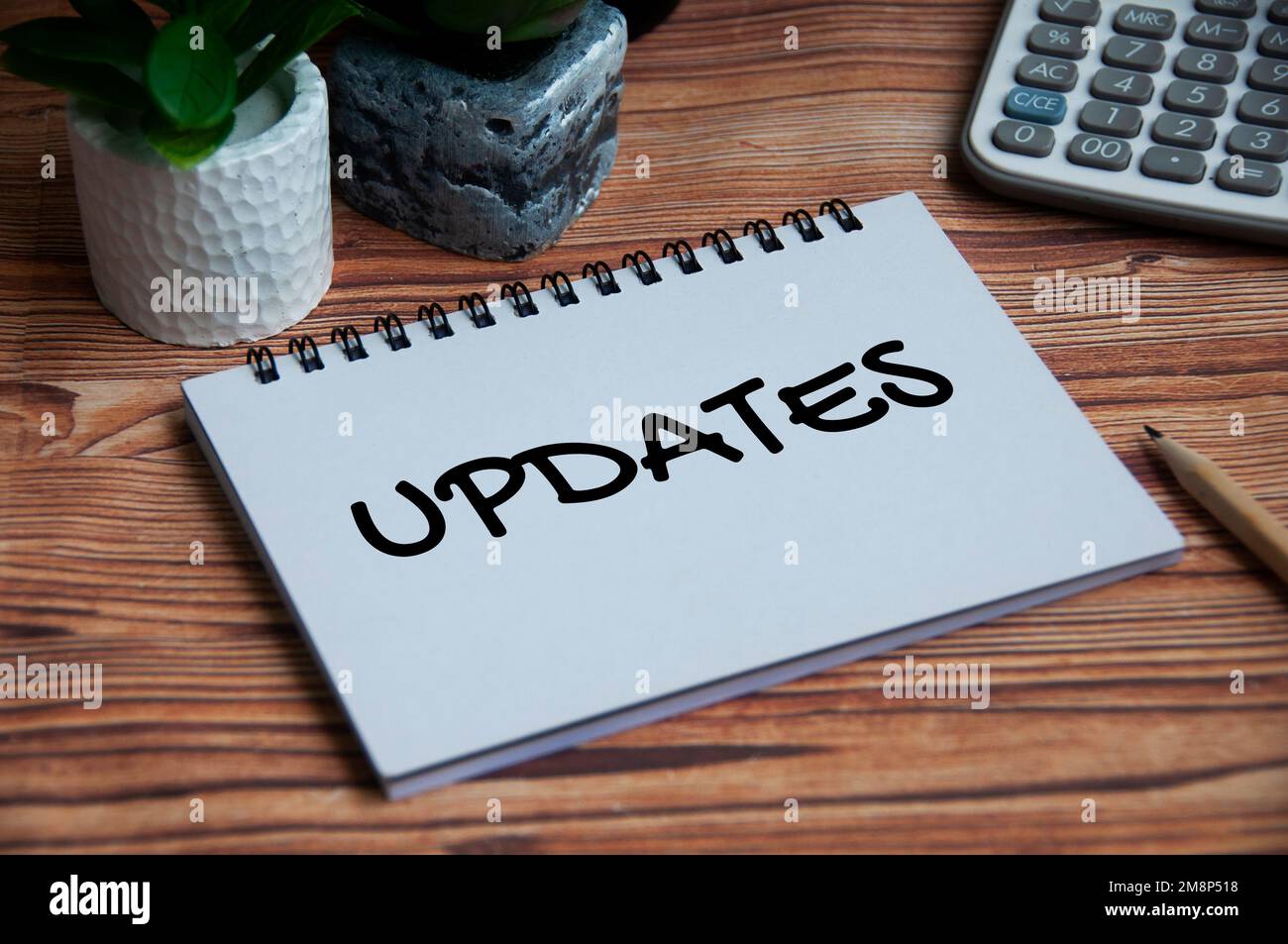 Updates text on notebook with green plant and calculator background ...