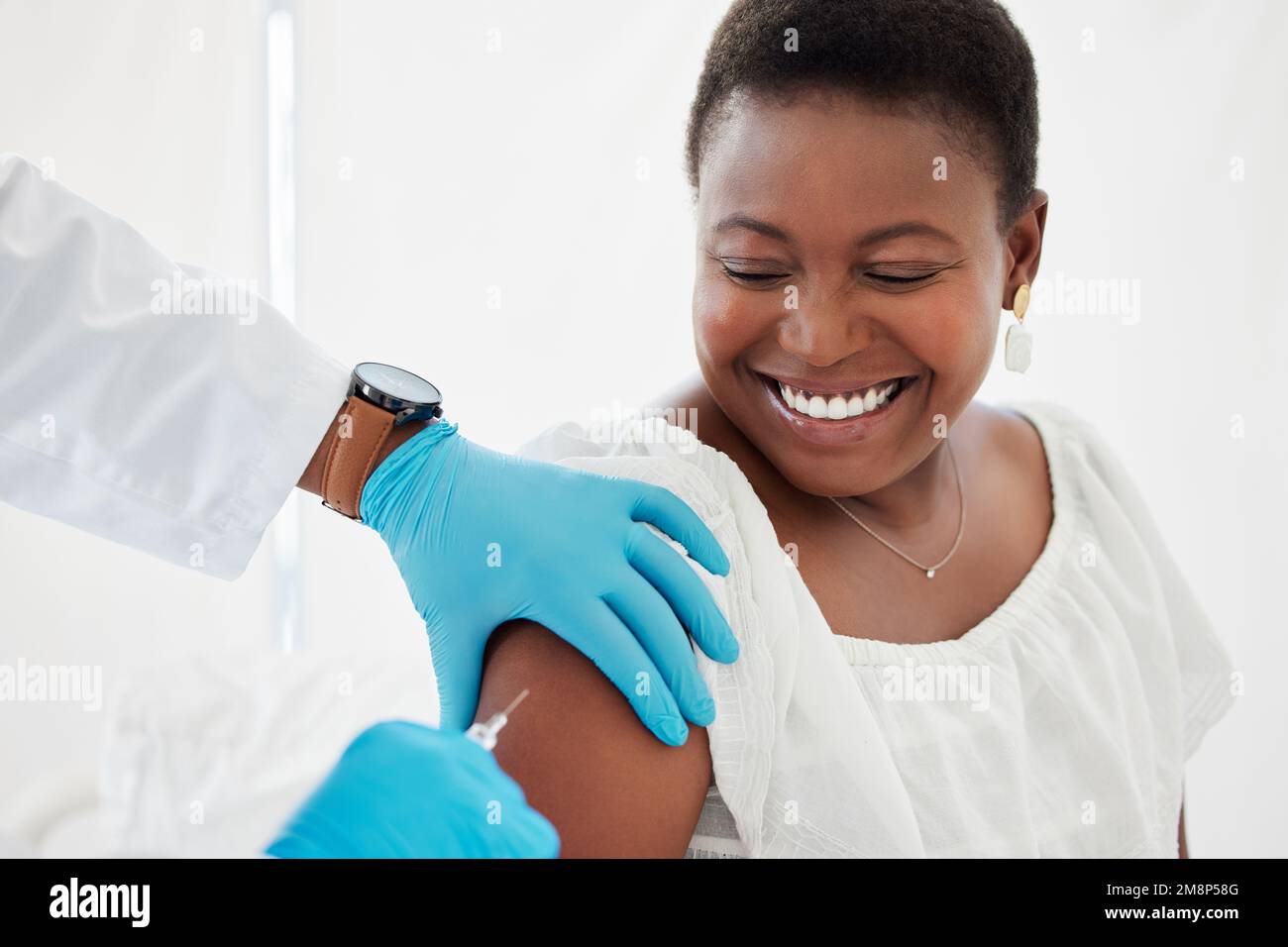 African american woman smiling before injection. Patient getting ...
