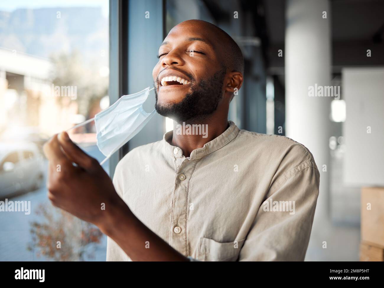 Young African american businessman removing his mask while at work. One ...