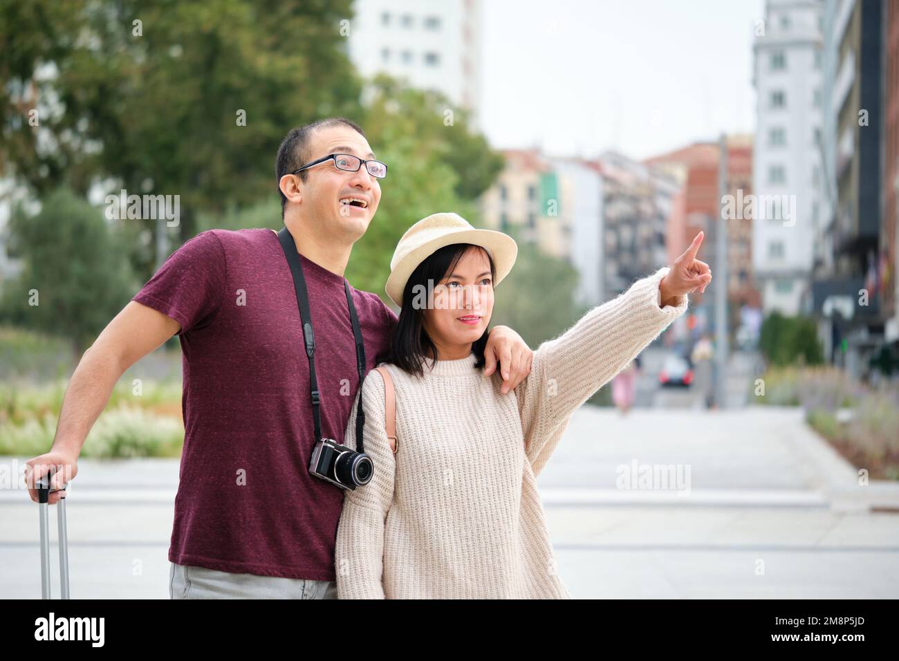 Happy multiracial couple of tourists exploring the city together and ...