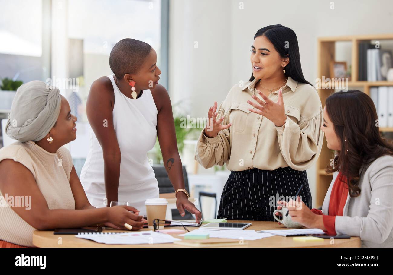 Diverse group of young ethnic business women having a meeting to ...