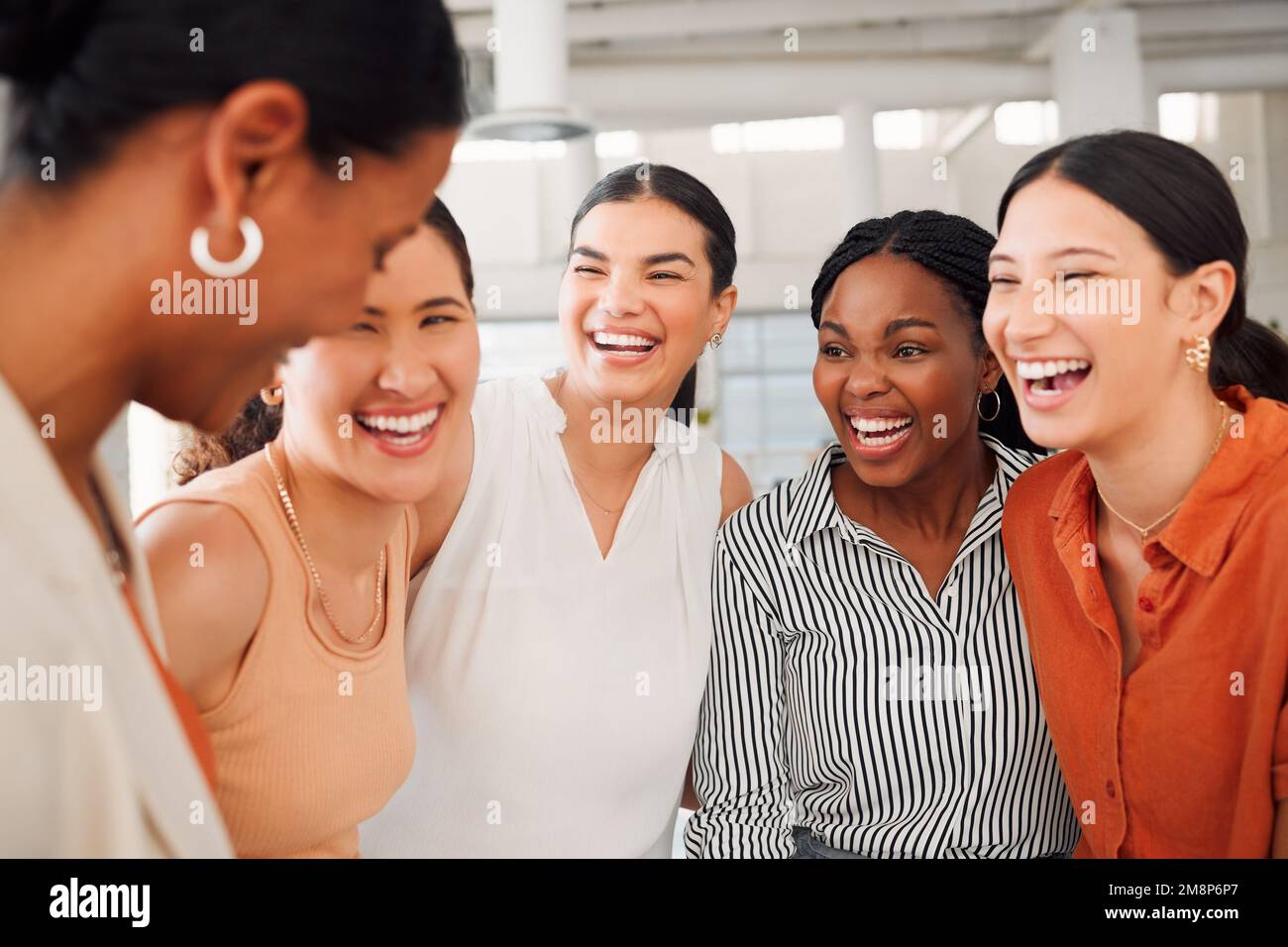 Diverse group of five cheerful businesswomen having a meeting together ...