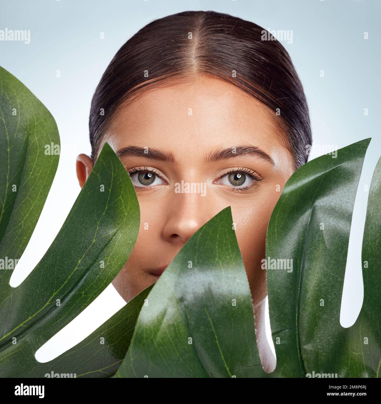 Closeup portrait of unknown woman covering her face with a green ...