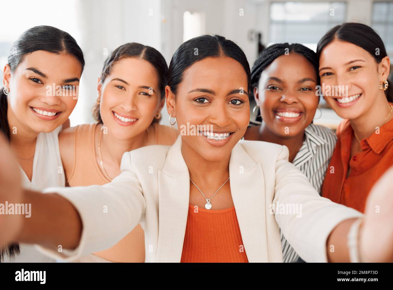 Portrait of a diverse group of five happy businesswomen taking a selfie together at work. Joyful ...