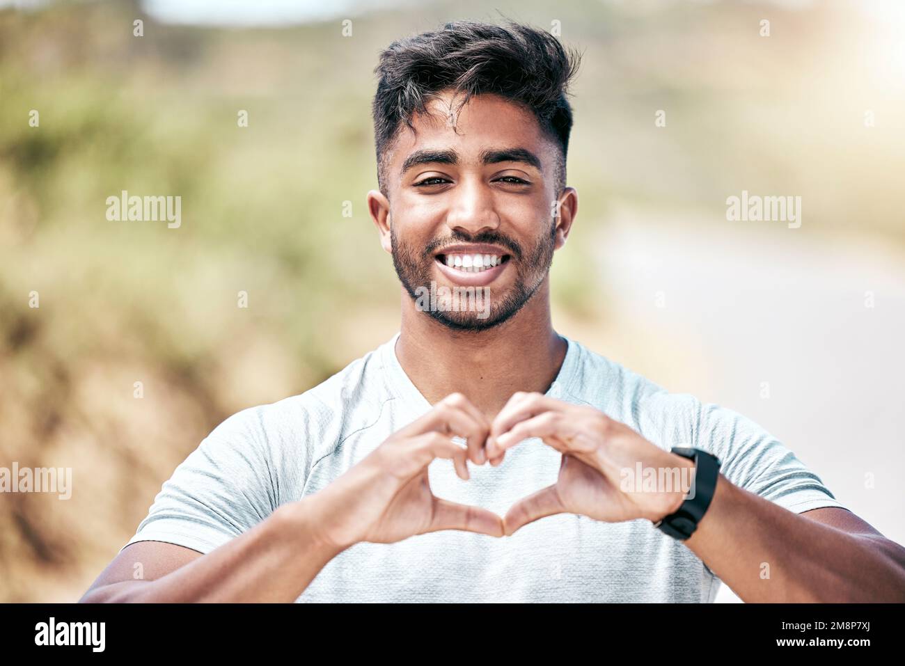 Portrait happy fit young mixed race man making a heart shape with his ...