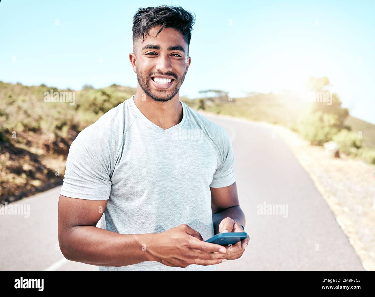 Portrait sporty mixed race man using his phone to chat online, browse ...