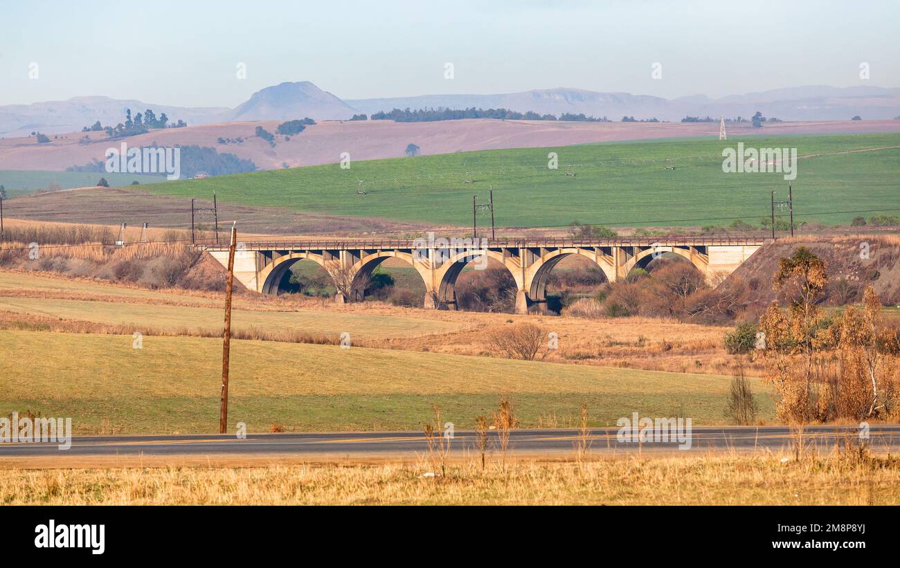 Rural farm fields alongside railway train bridge road scenic mountain ...