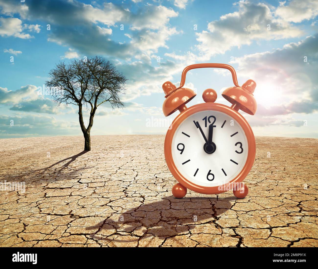 Alarm clock with five minutes before twelve o'clock on arid cracked ...