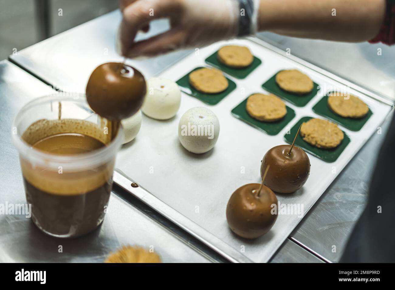 Unrecognisable baker glazing and assembling caramel apple desserts ...