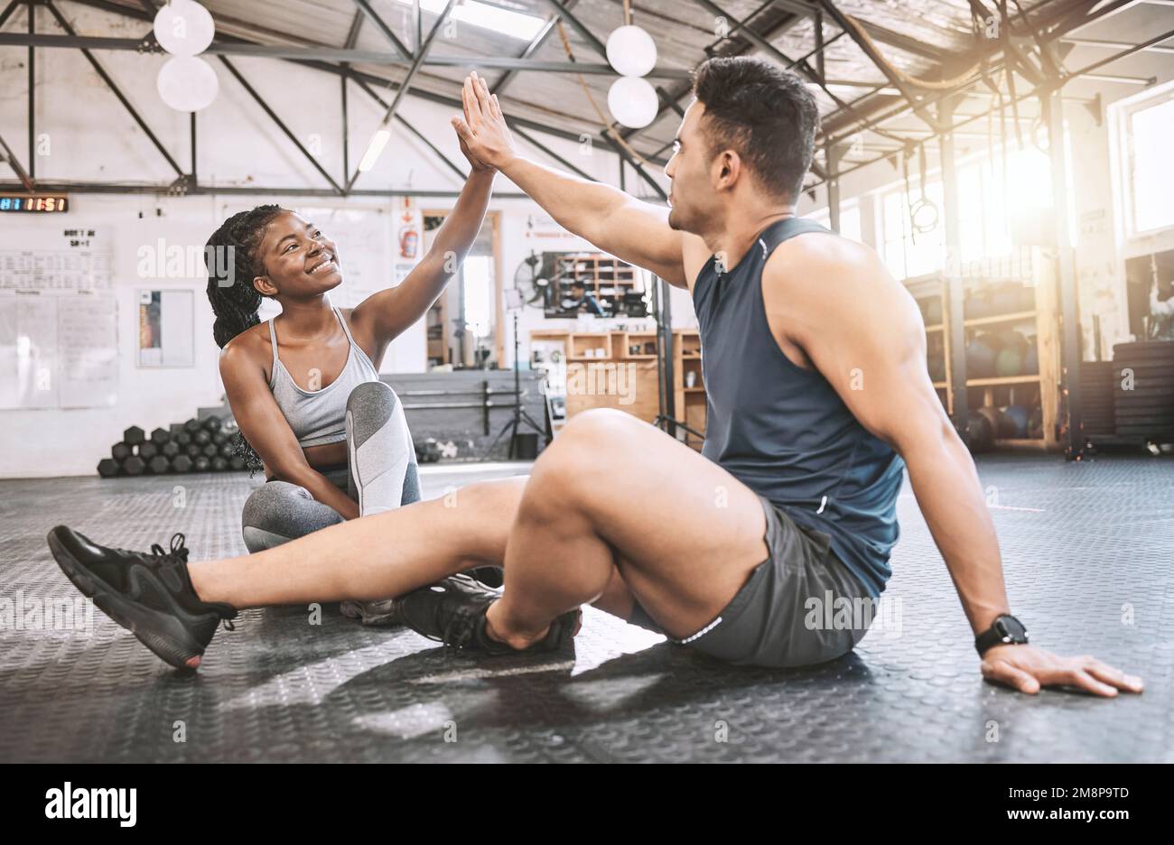 Trainer giving his client a high five after a workout. Young friends ...