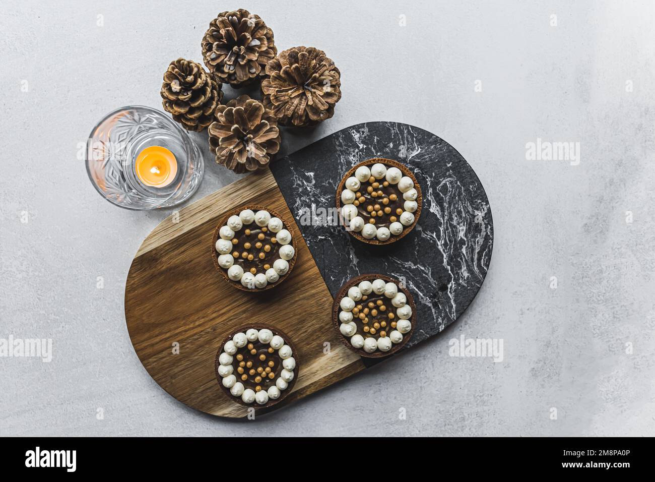 Top-down view of four chocolate mini dessert tarts on wooden and stone ...