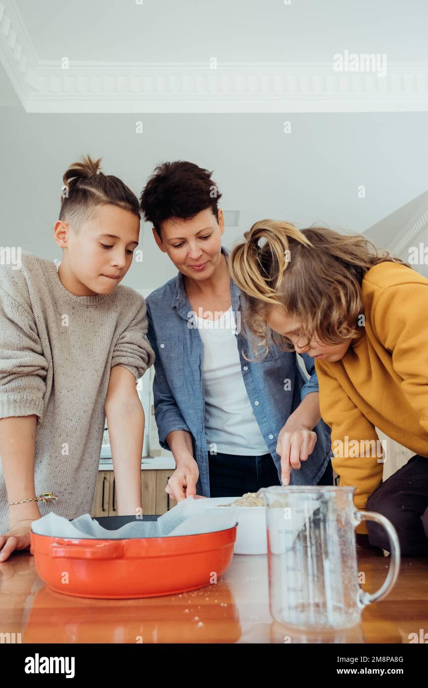 Friendly togetherness of parents and children.Mother cooking with sons ...
