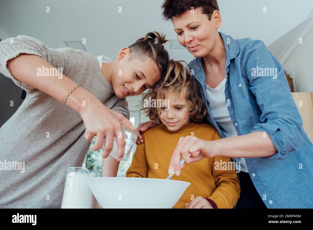 Friendly togetherness of parents and children.Mother cooking with sons ...