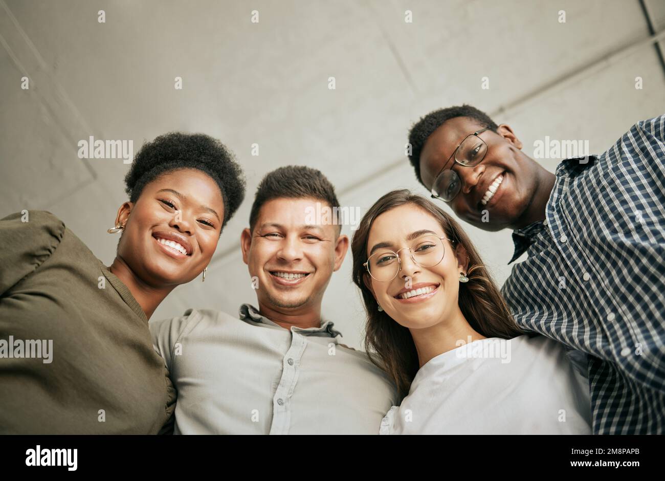 Portrait of happy united young business team hugging each other ...