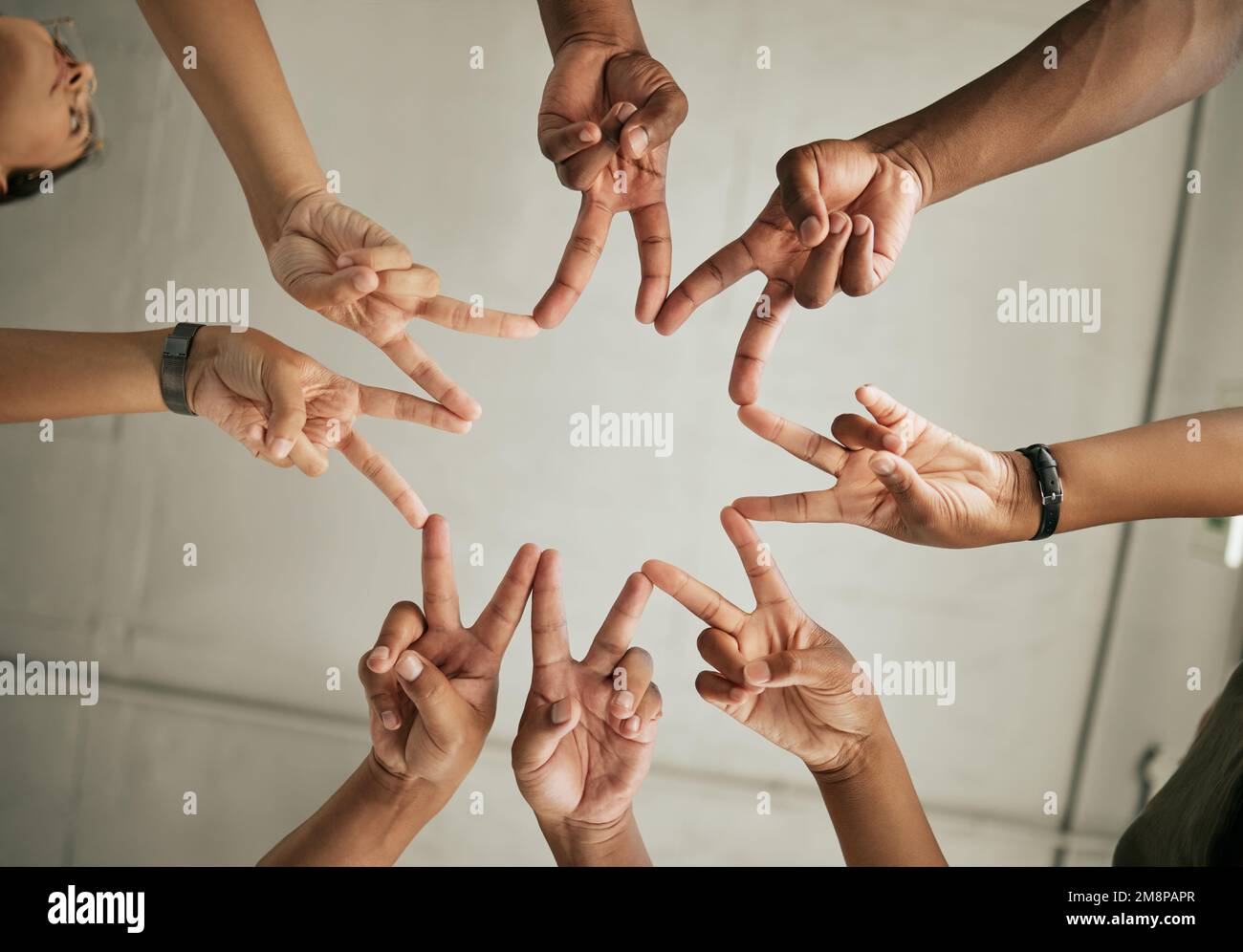Close up of hands forming a star shape with the v-sign, from below ...