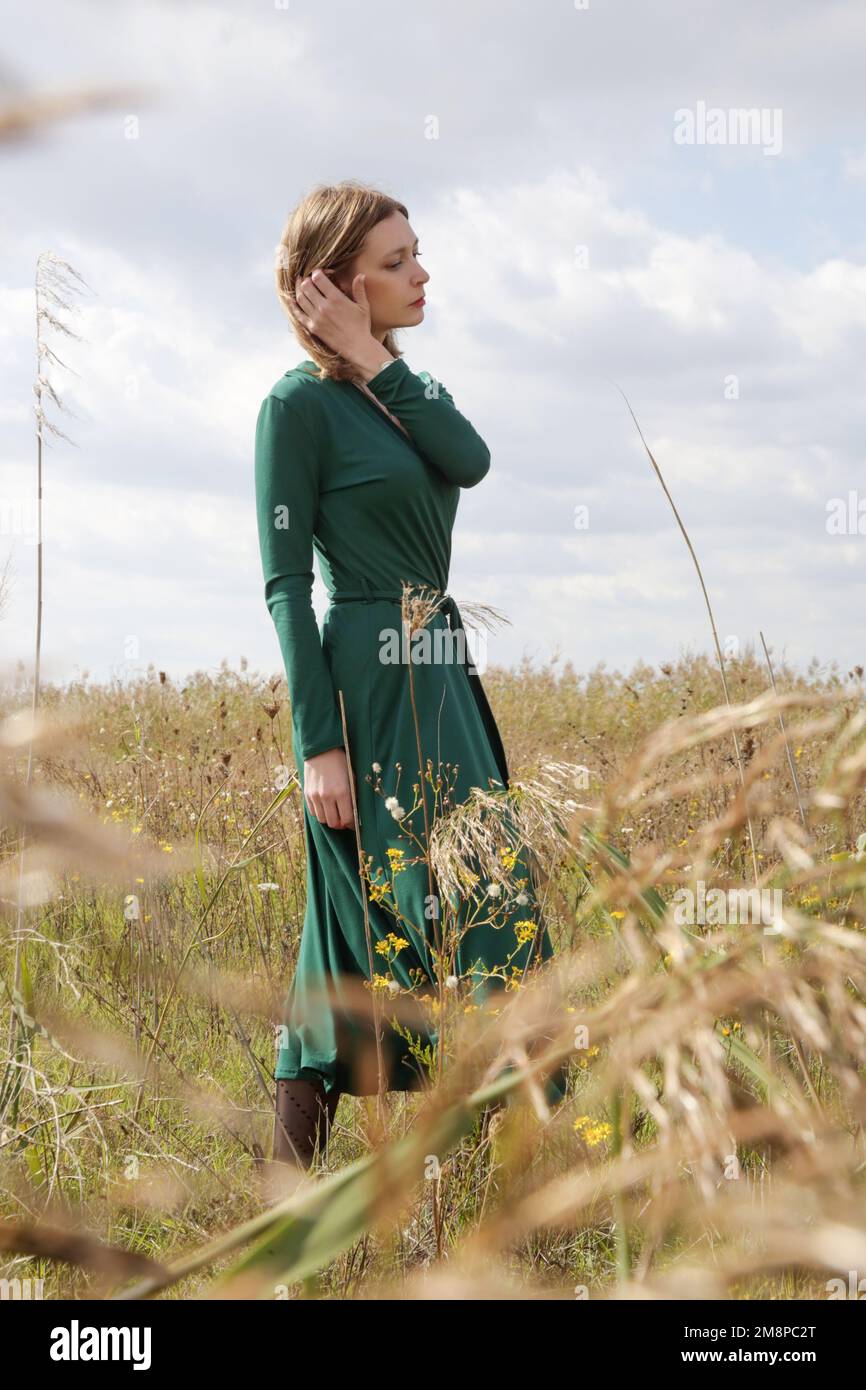 Serie of photos of female model in green dress posing on meadow ...