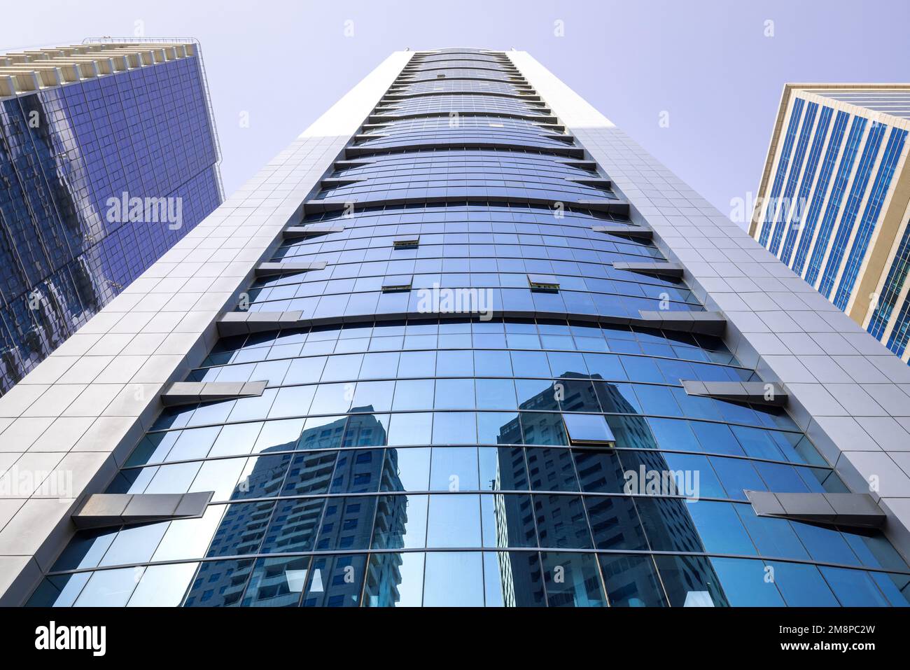 Symmetrical view of a modern skyscraper with a glass facade in Dubai ...
